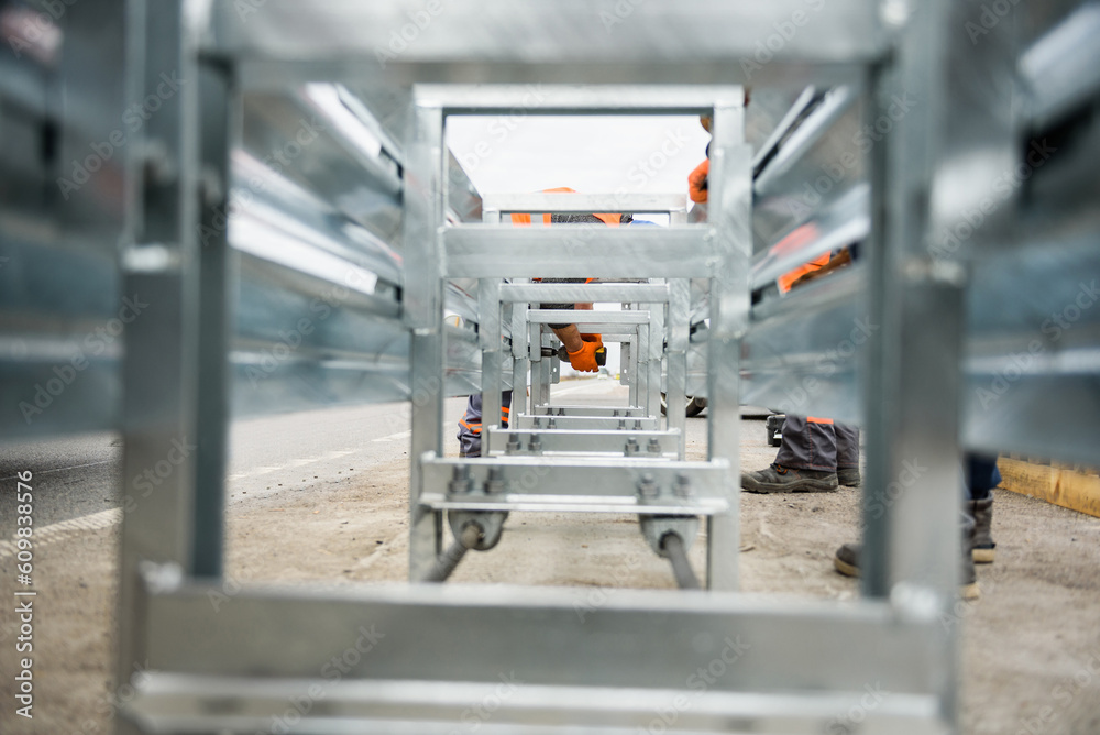 Installation of median crash barriers on highway. Metal road fencing of ...