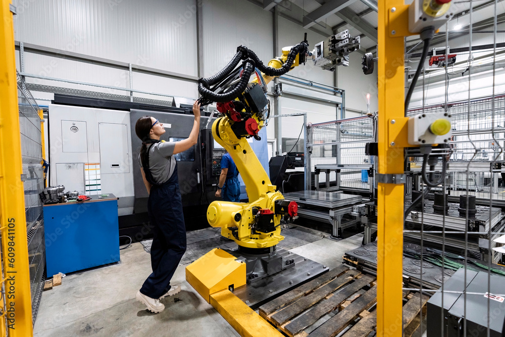 Maintenance engineer working with robotic arm in modern factory Stock Photo | Adobe Stock
