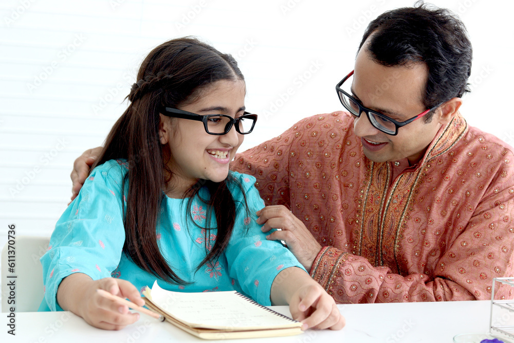 Cute Indian school student girl in traditional dress and glasses do ...