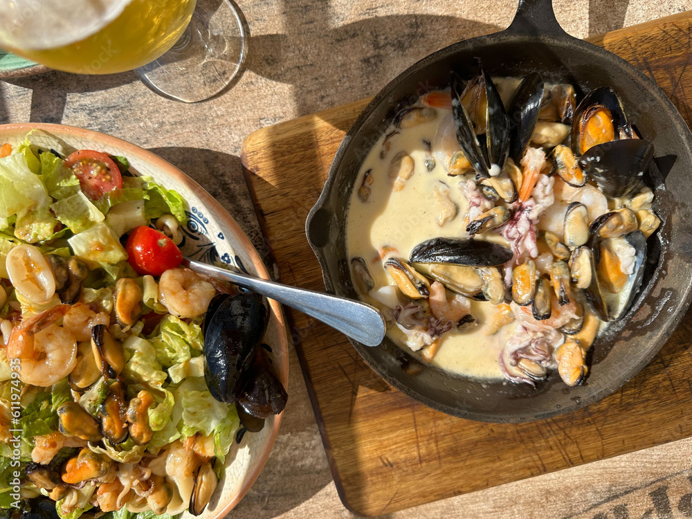 Large black pan of seafood : mussels, snails and shrimps in cream ...