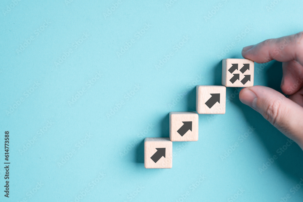 Hand holding arrow up symbol icon wooden block growth increase on blue ...