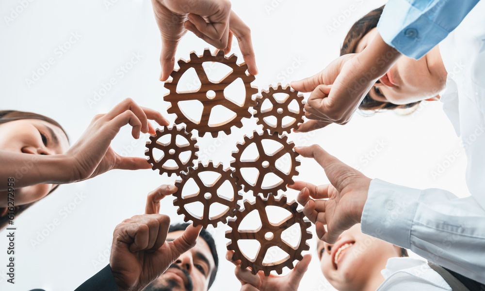 Below view office worker holding cog wheel as unity and teamwork in ...