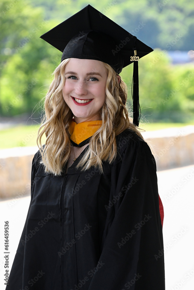 Smiling female college graduate with blonde hair in cap and gown Stock ...