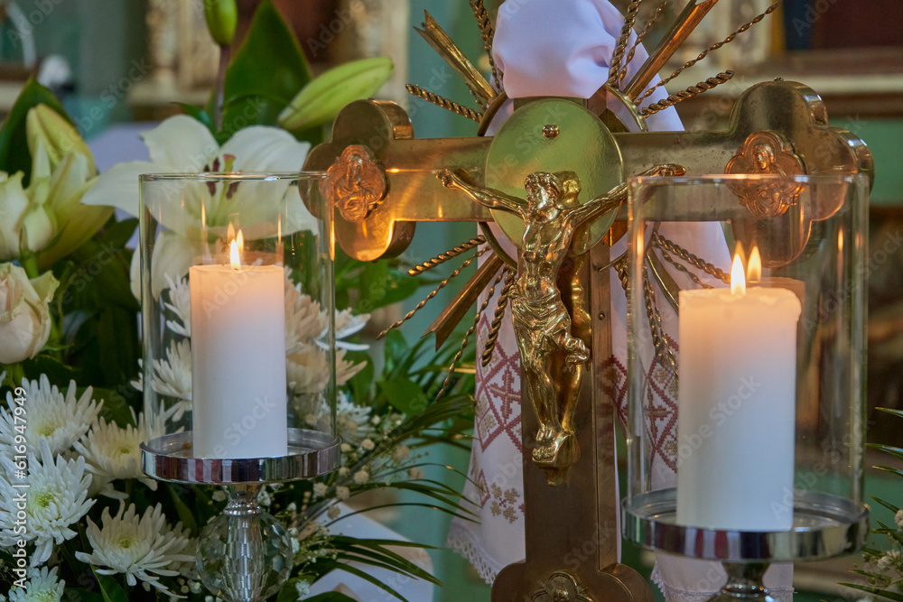 crucifixion of Christ and candles,a gilded cross in the church with the ...