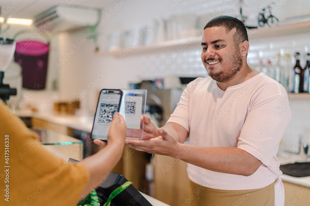 attendant receiving bill payment by scanning QR code at a coffee shop ...