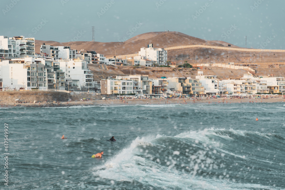 Personas a contraluz disfrutando de las olas del mar en la hora dorada ...