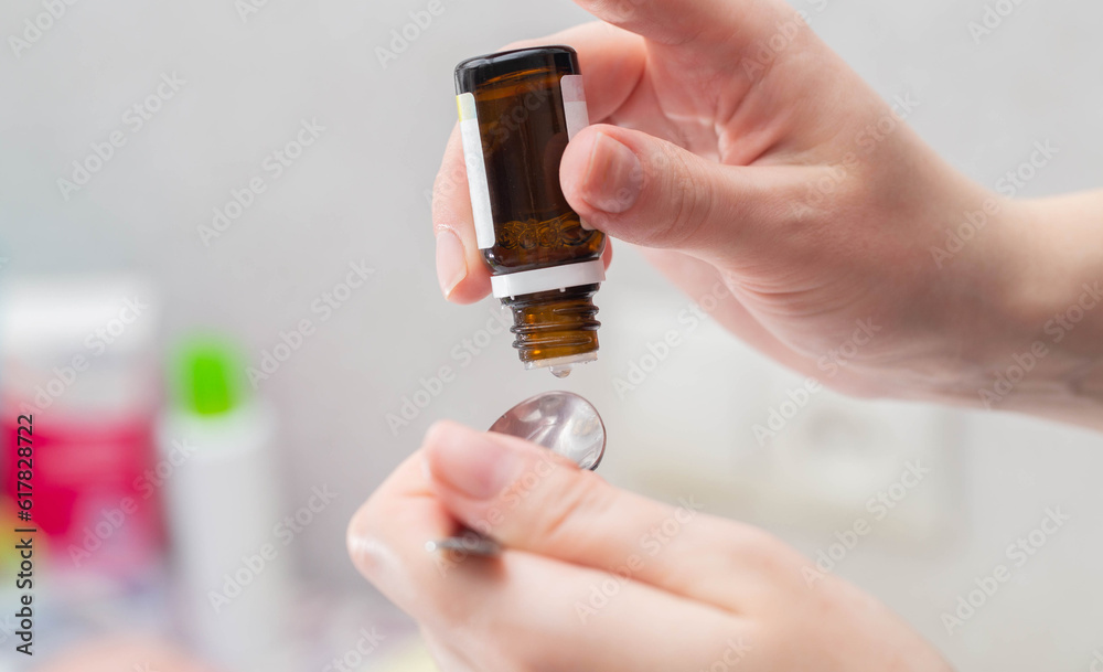 Mother drips medicinal drops into a spoon for the treatment of an ...
