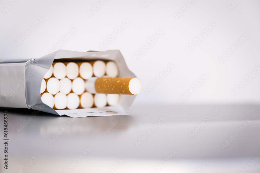 Close up cigarette filter sticking out of full pack lying on shiny ...