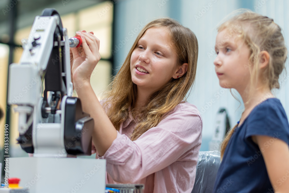 Foto de Stock Kid female teen child enjoy Machine Learning Robot arm is ...