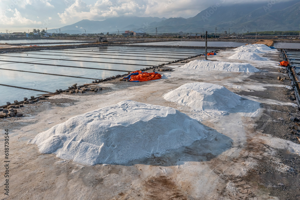 Field and Sea salt pile pyramid ready for harvest in salt farm. Sea ...