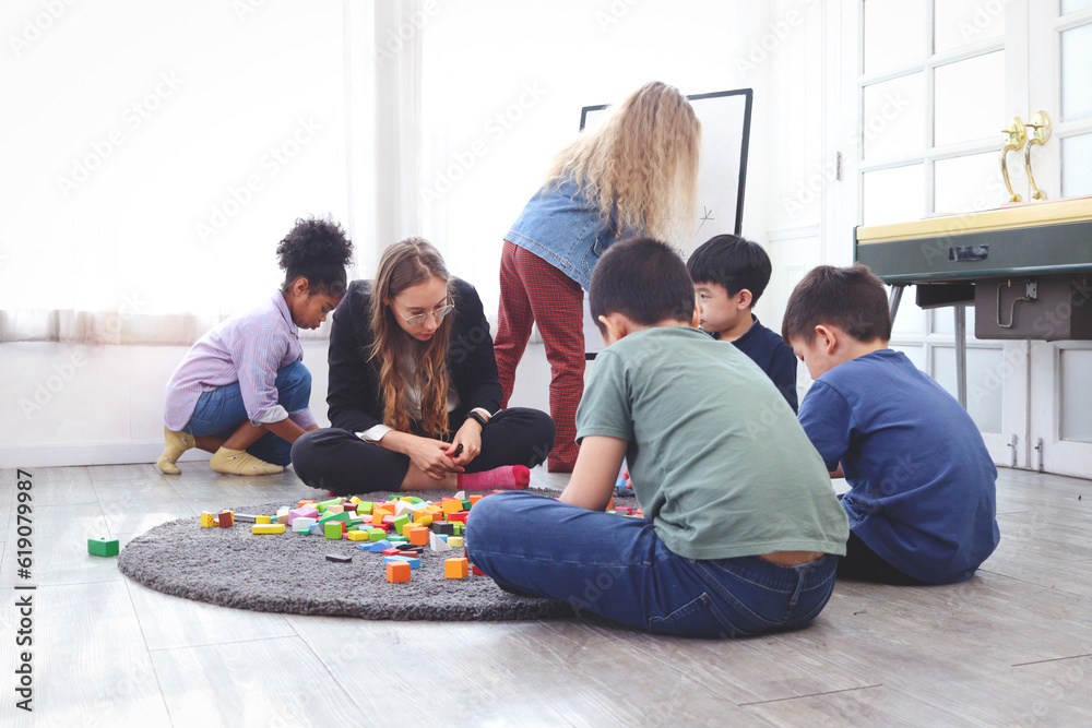 Group of primary school children study and play together in classroom ...