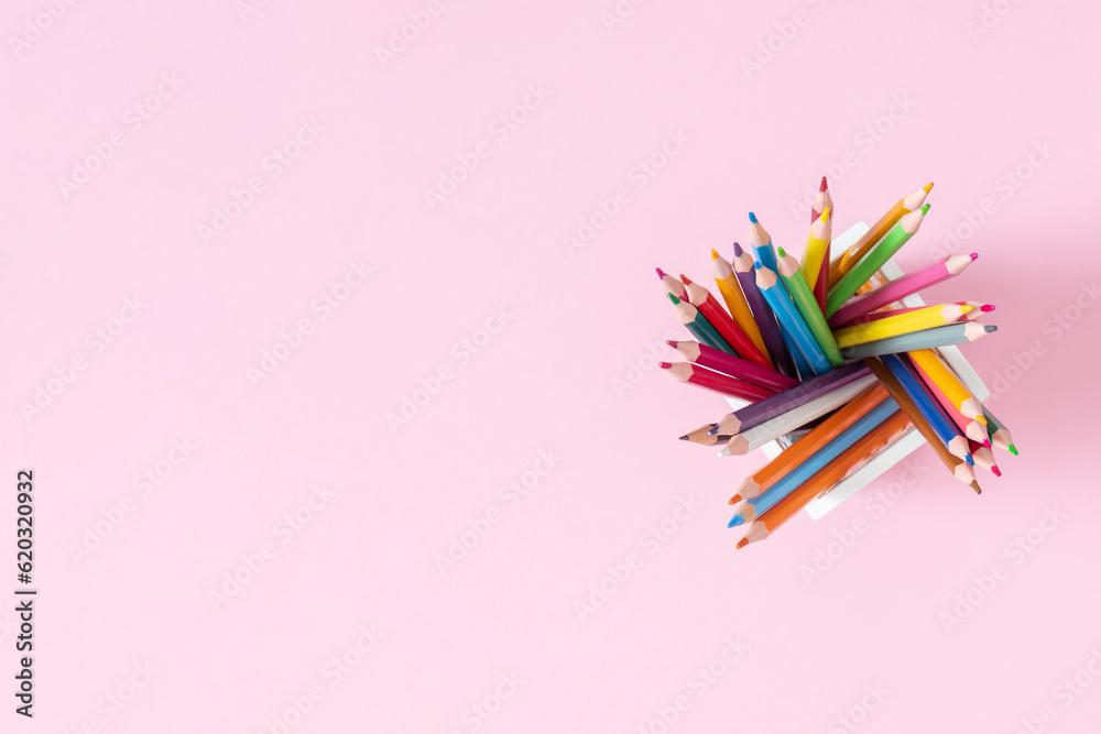 Top view of colored pencils in a stand isolated on a pastel pink ...