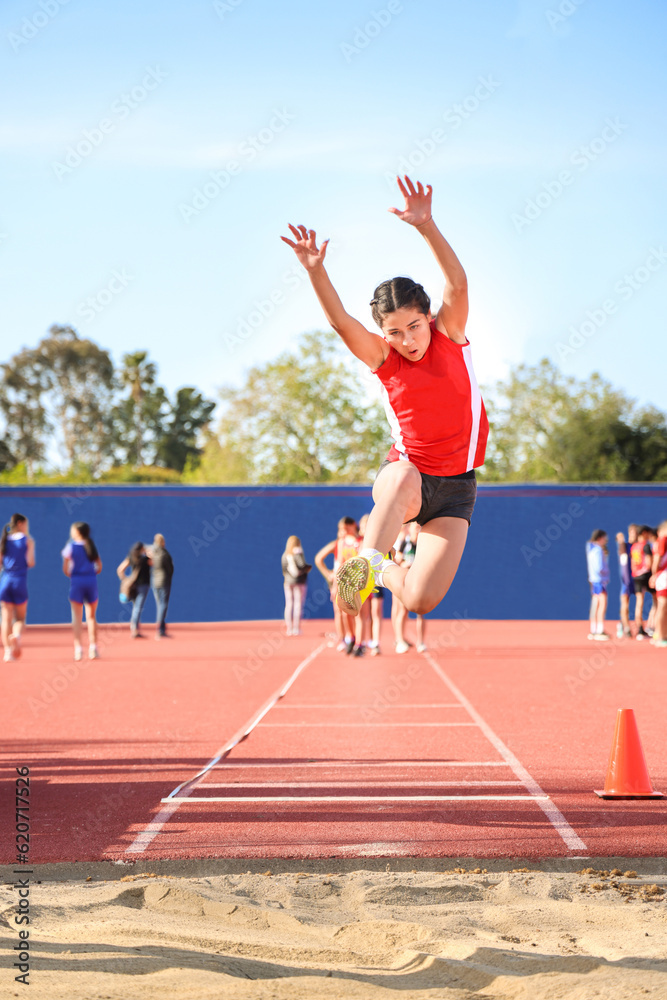 Teenage Girl Doing a Long Jump Stock Photo | Adobe Stock