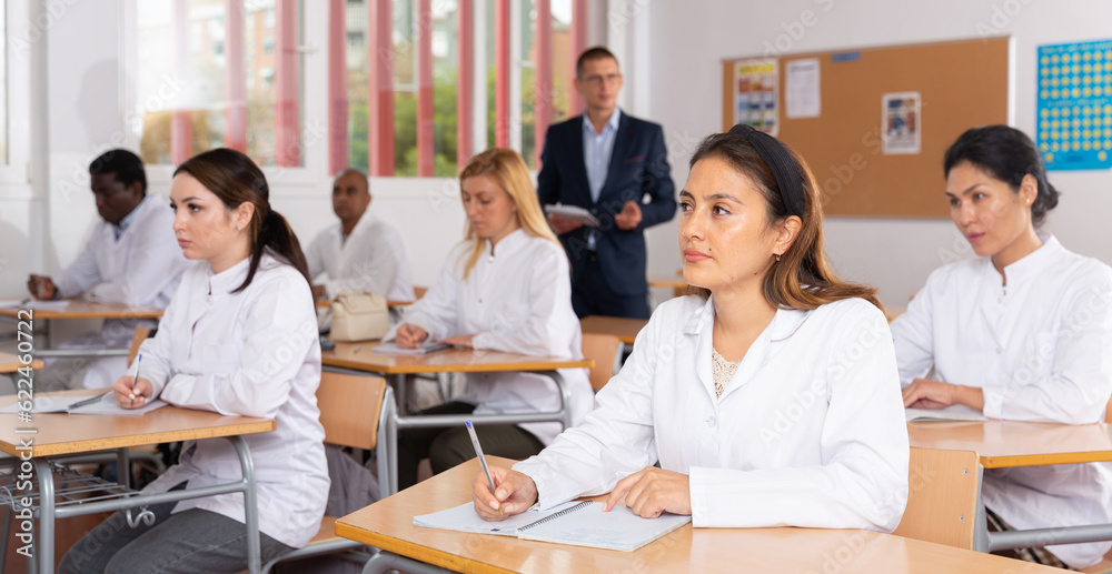 Medical students writing in notepads during lesson Stock Photo | Adobe ...