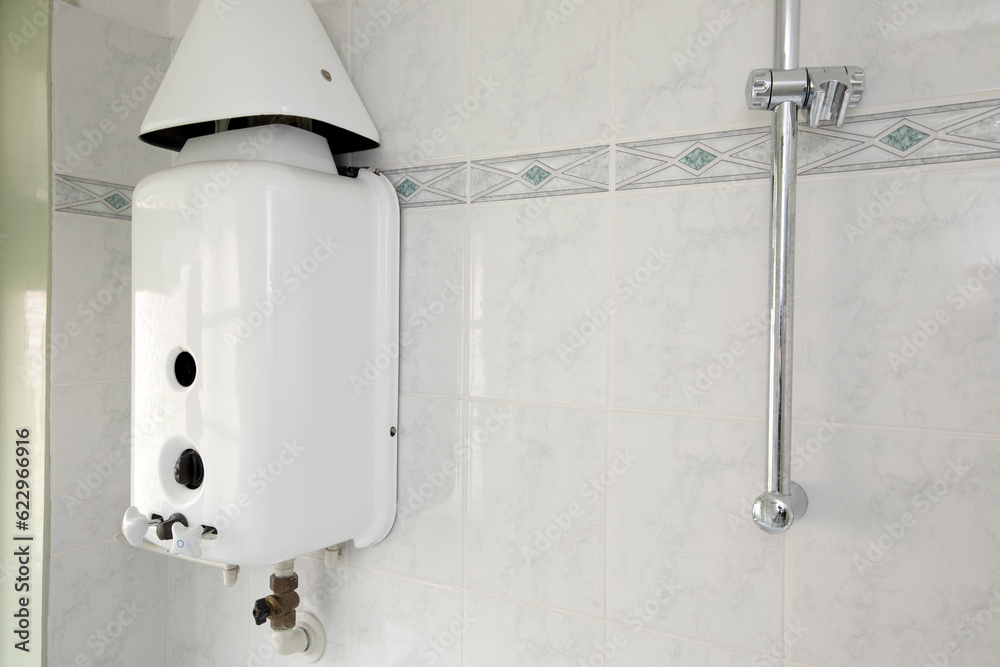 Household budget water heater hanging on the wall in boiler room ...