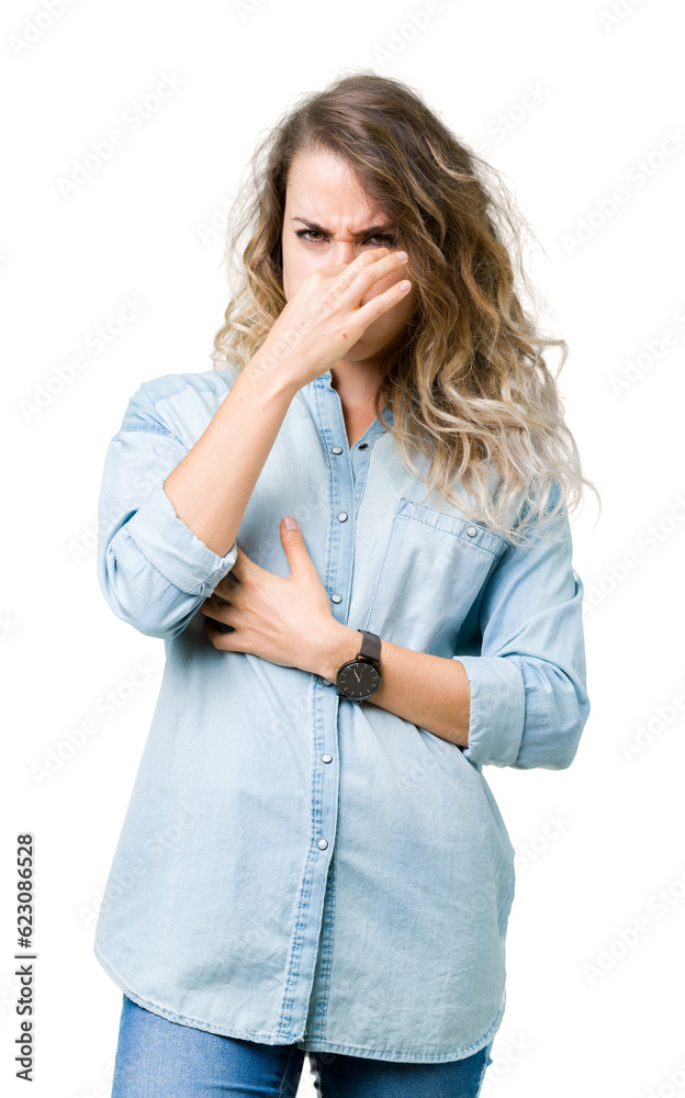 Beautiful young blonde woman over isolated background smelling ...