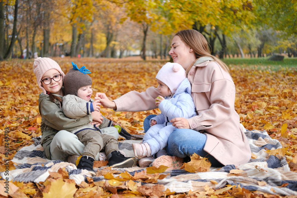 The large family. Mom with her three children spend time sitting on a ...