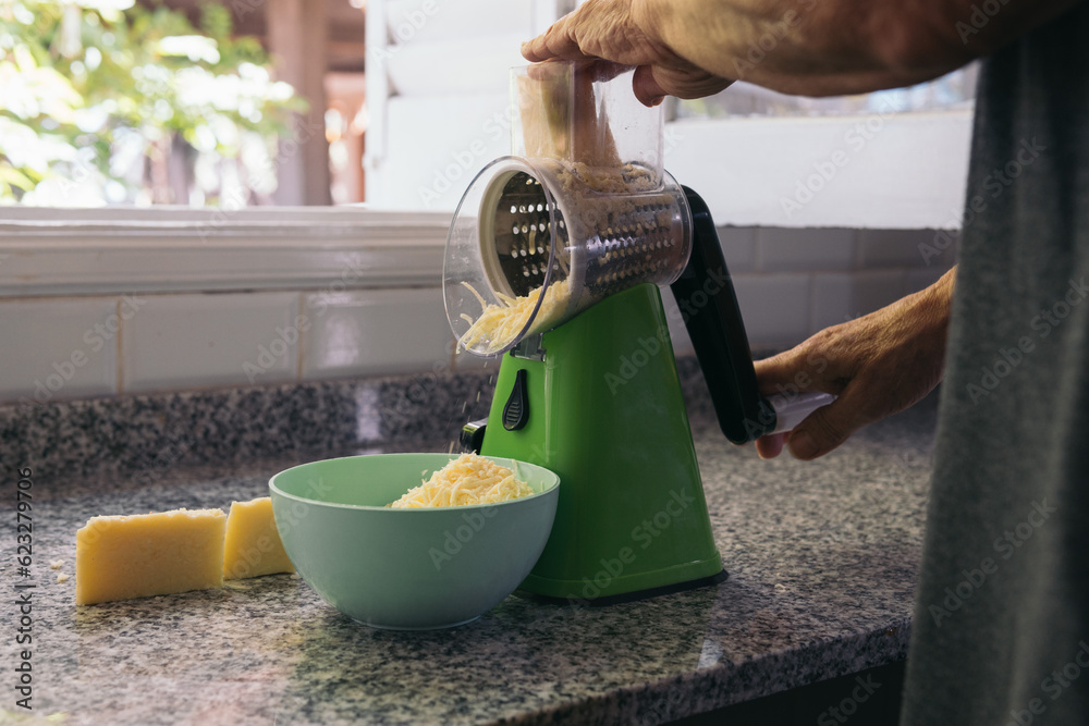 Foto de Stock Unrecognizable Elderly woman Using a Modern Manual Grater ...