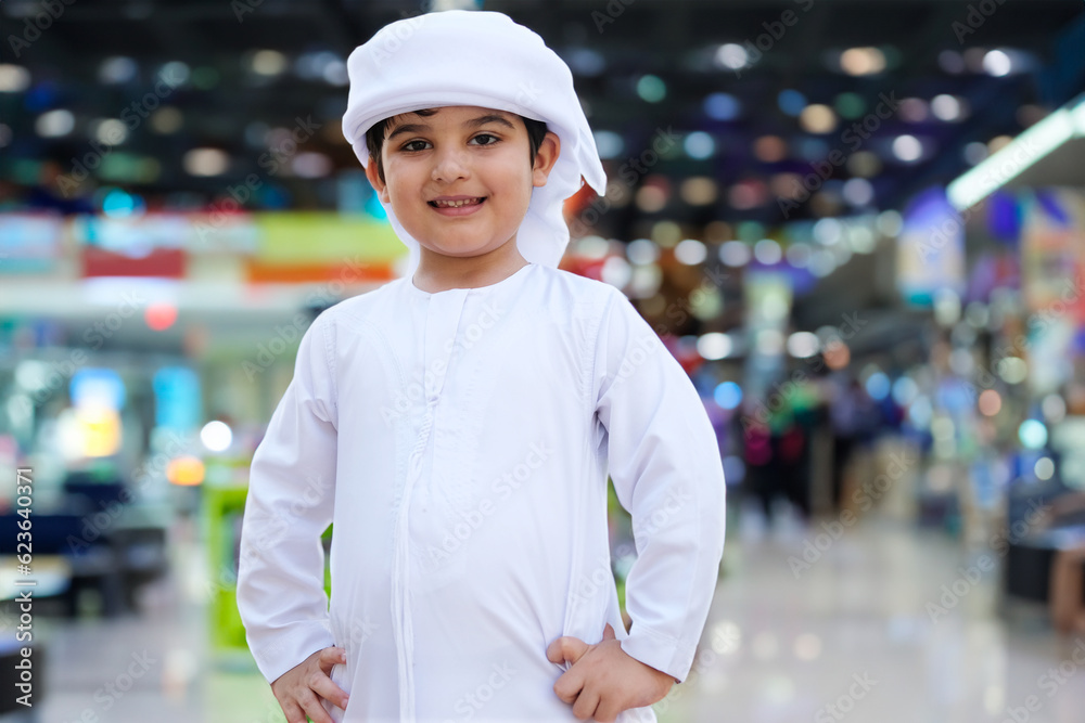Young Arab boy inside a shopping mall. Emirati kid wearing Kandura ...