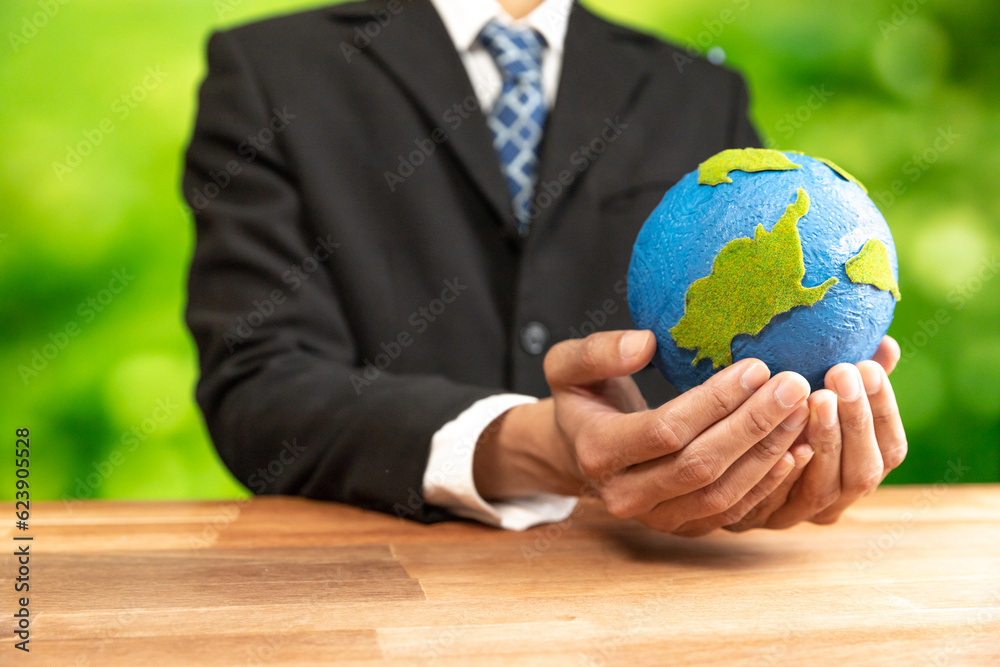 Foto Businessman holds paper earth as symbol of eco environmental ...