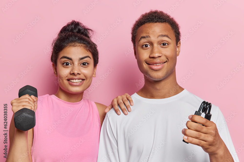 Studio portrait of pair of young smiling glad European lady and African ...