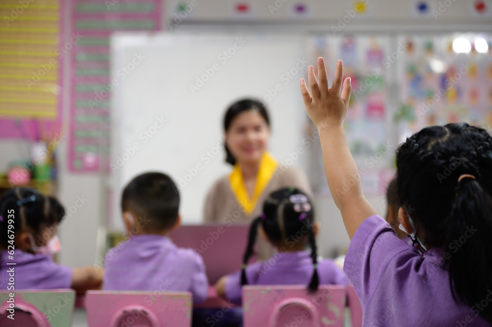 Education and school concept Asian kindergarten children raise their ...