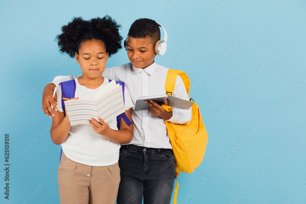 African American schoolboy and schoolgirl are reading an outline ...