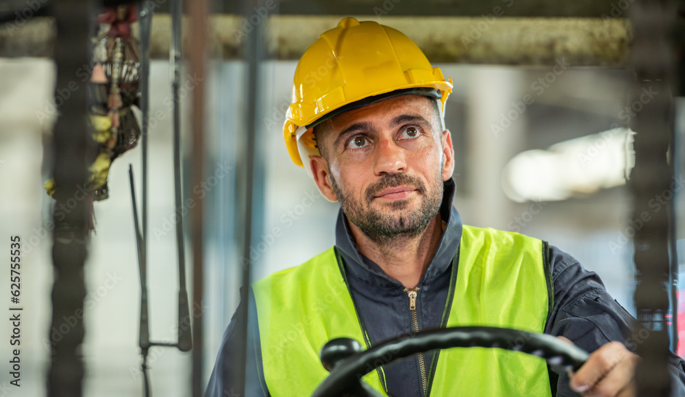 Portrait of forklift truck driver man smiling in old factory warehouse ...
