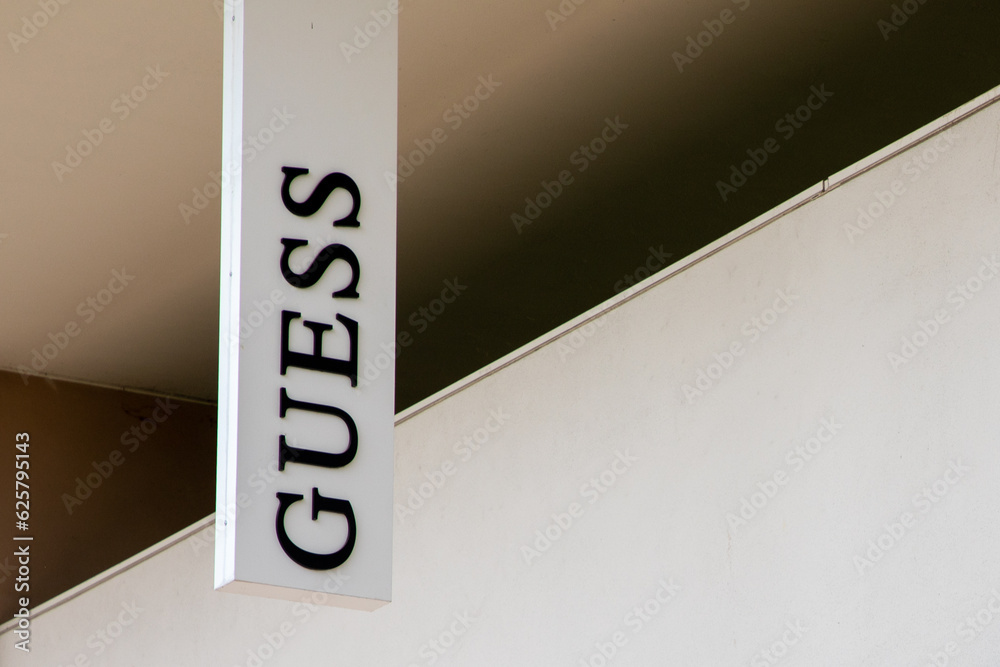 Guess storefront text and logo signboard shop sign on wall facade store ...