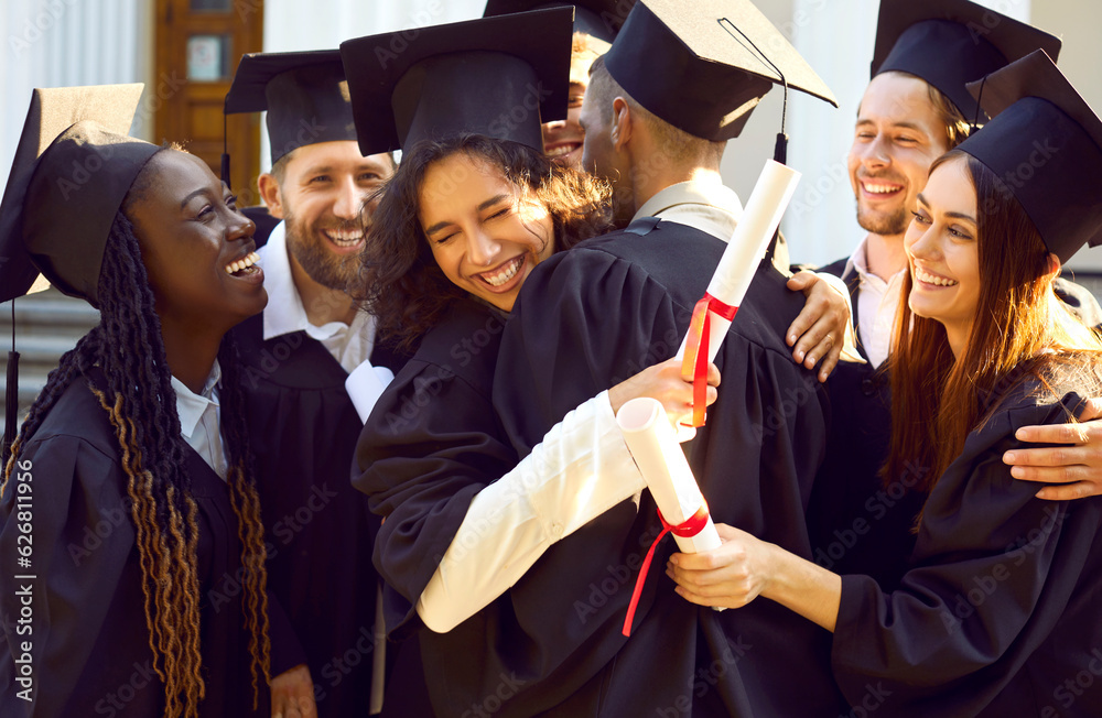 Excited students hugging each other after receiving diplomas at ...