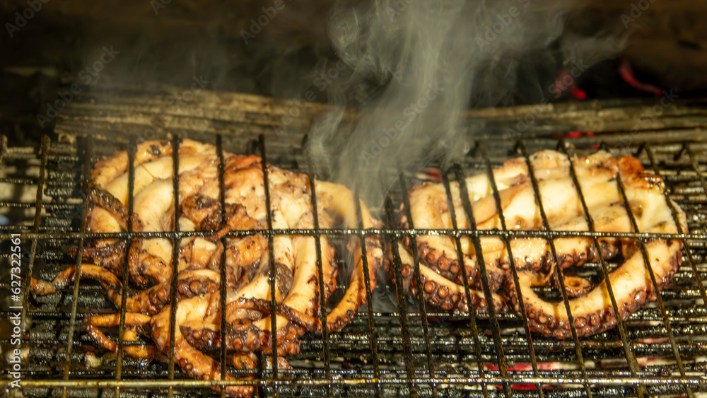 Octopuses fresh out of the Aegean Sea are cooked on the grill fire ...