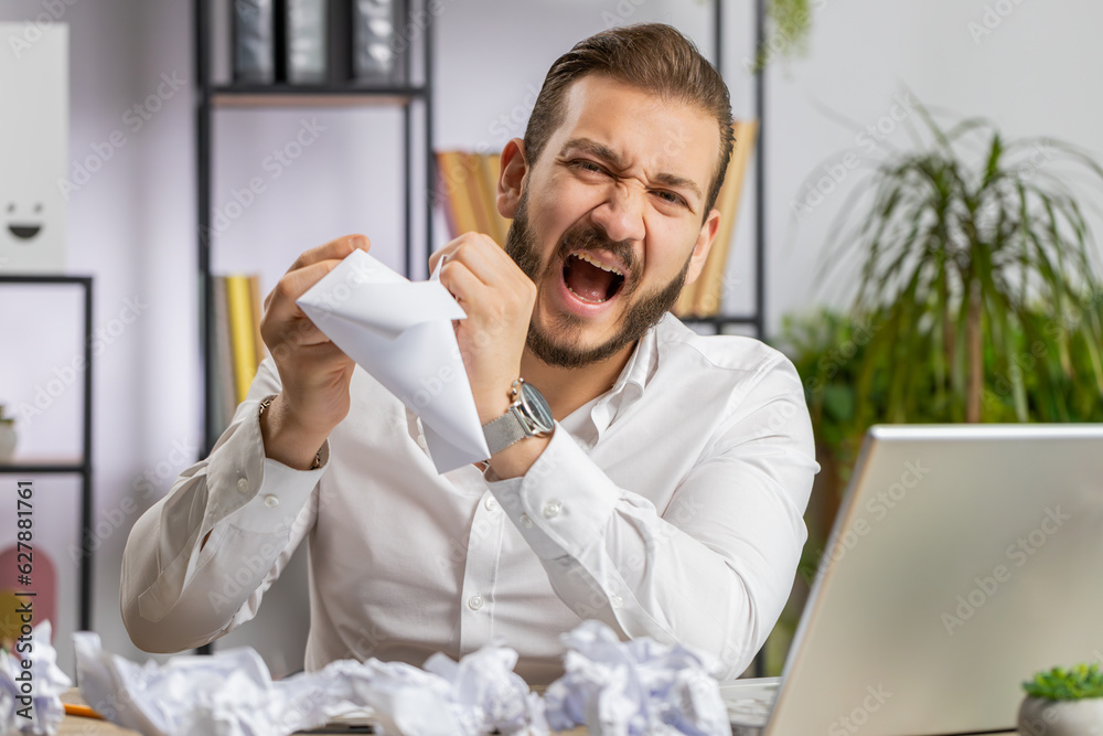 Angry furious businessman working at office throwing crumpled paper ...