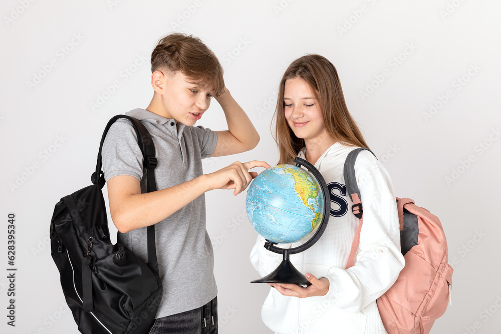 Two schoolchildren, teenagers are looking with interest at the small ... Two schoolchildren, teenagers are looking with interest at the small ...