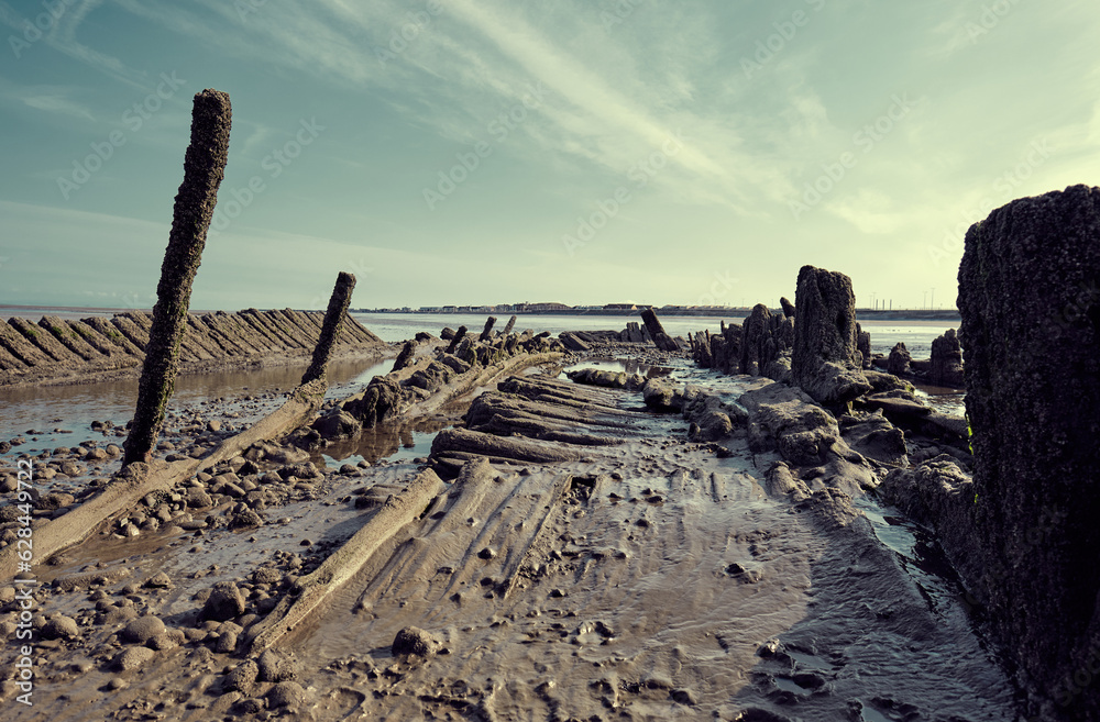 An old historic wooden shipwreck vessel carcass exposed on a desolate ...
