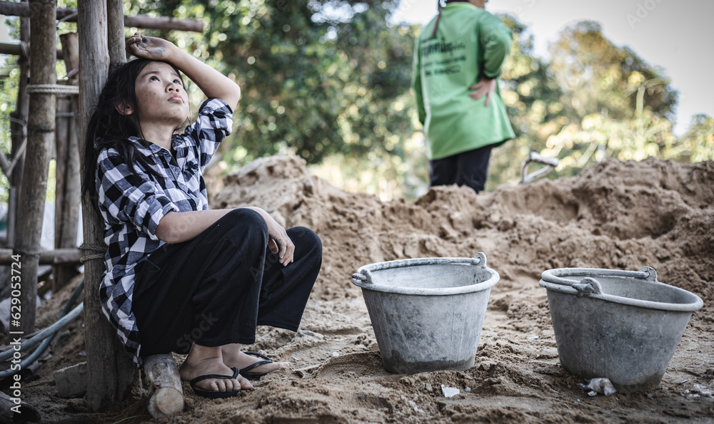 Exhausted child girl sitting construction background. child labor and ...