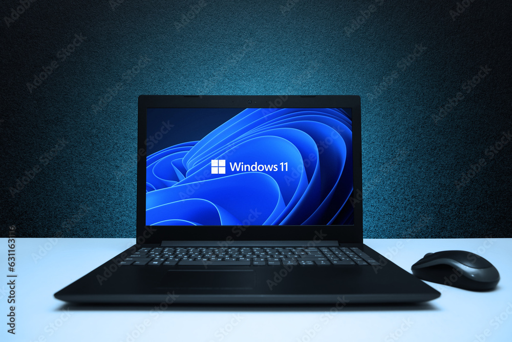 Windows 11 logo on the screen laptop computer with mouse on black ...