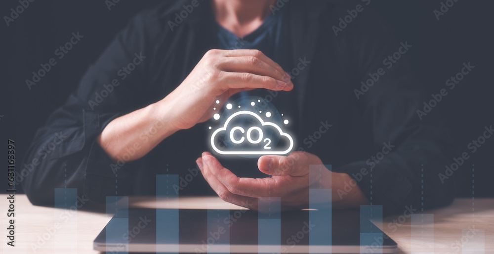 Hand holding virtual sign of CO2 reducing icon concept of decrease carbon dioxide emission ...