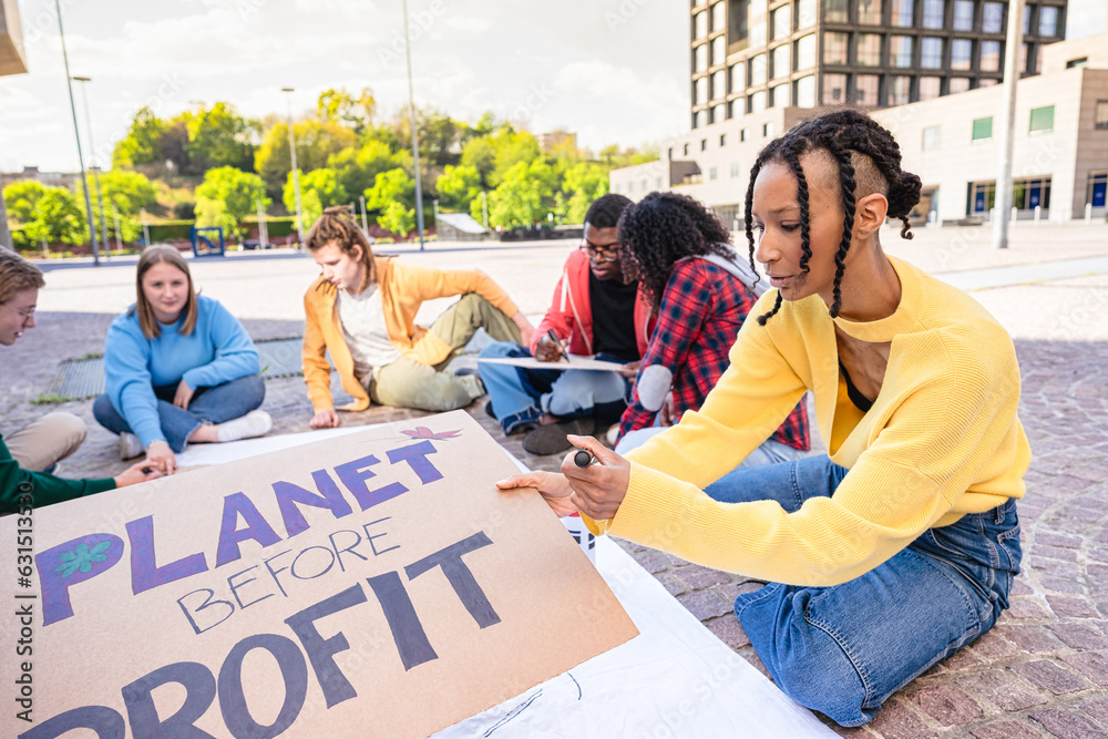 Young activist people making a banner eco-themed slogans to participate ...