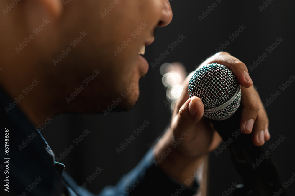 Attractive singer man singing music and playing guitar on stage with ...