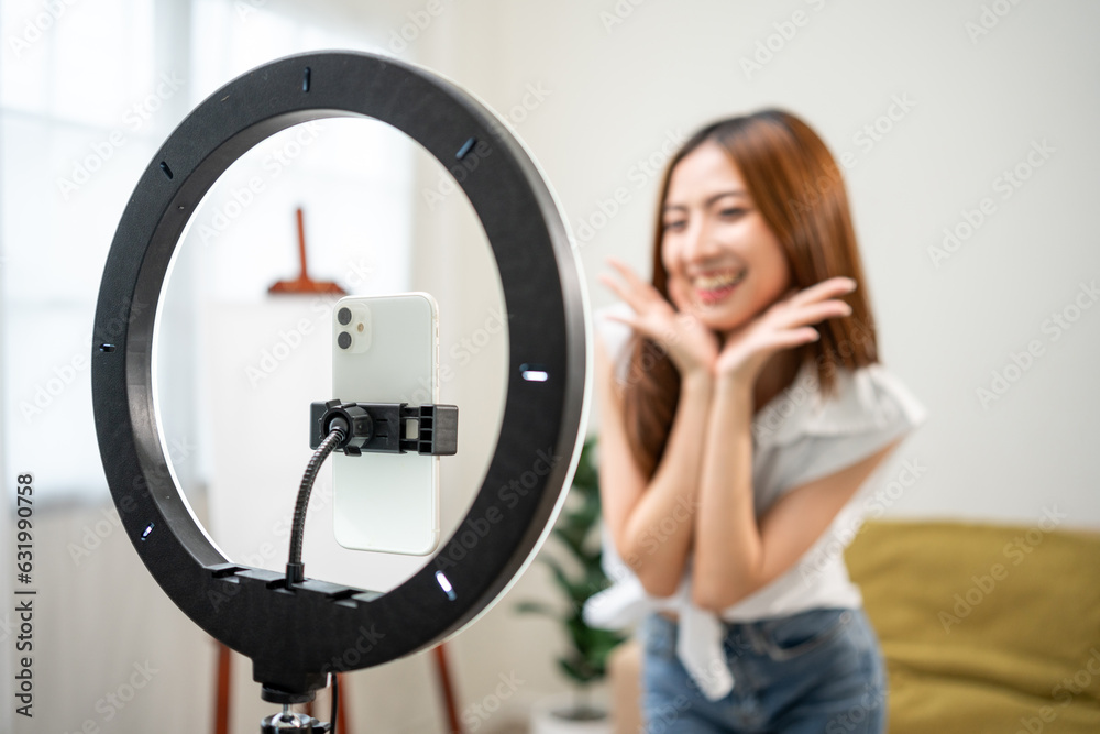 Young trendy influencer asian woman dancing on mobile phone at home in ...