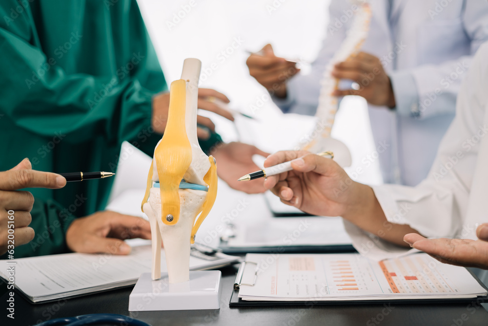 serious doctors team are analyzing fracture knee model showing the ...