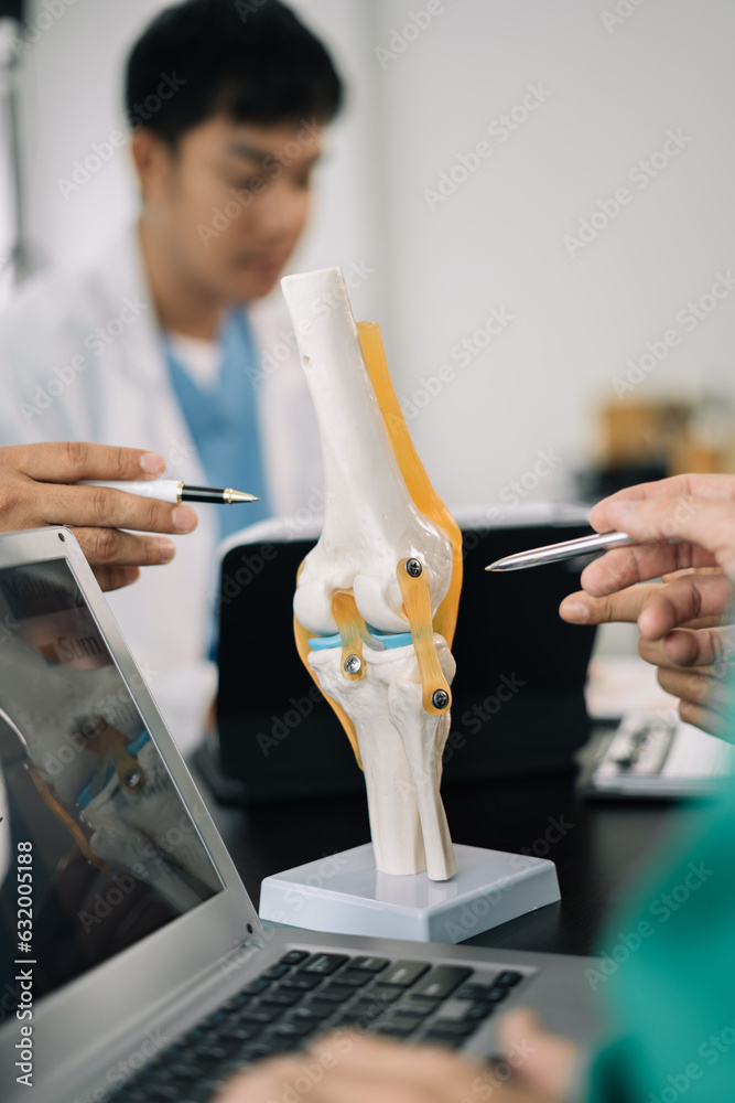 serious doctors team are analyzing fracture knee model showing the ...