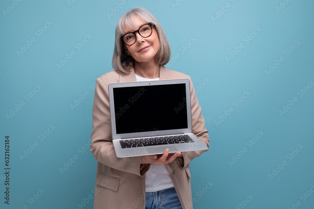60s woman in jacket showing laptop screen mockup on bright background ...