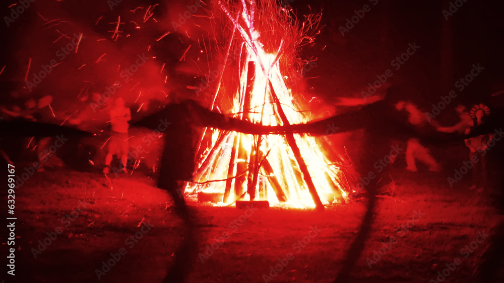 Huge fire at night and young people around. Pagan festival of Walpurgis ...