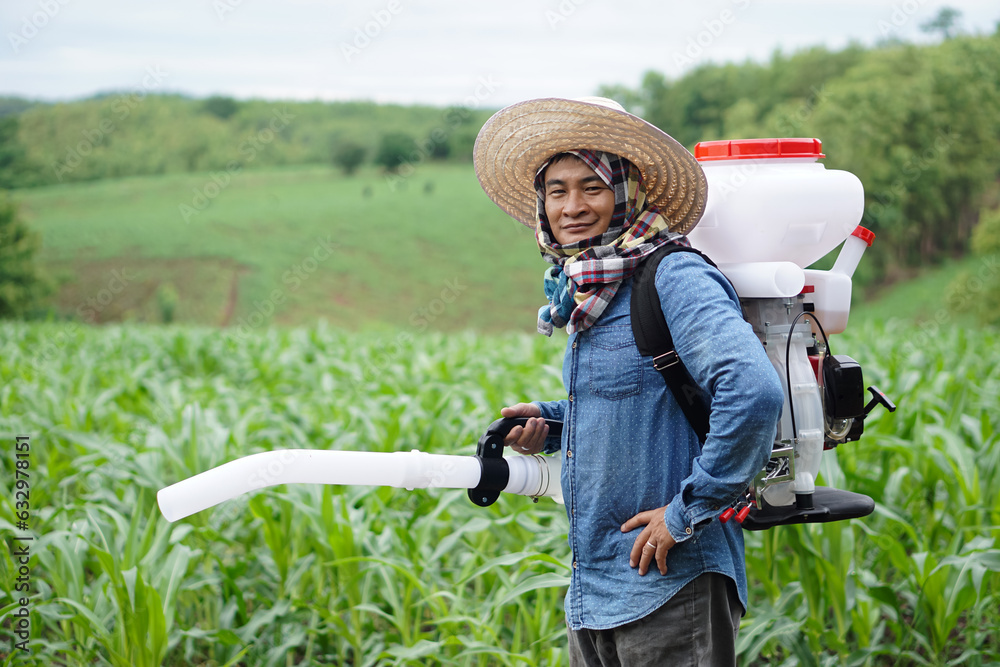 Asian man farmer carry fertilizer sprayer machine on back, stand at ...