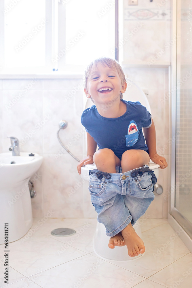 Cute child, boy, sitting on the toilet Stock Photo | Adobe Stock