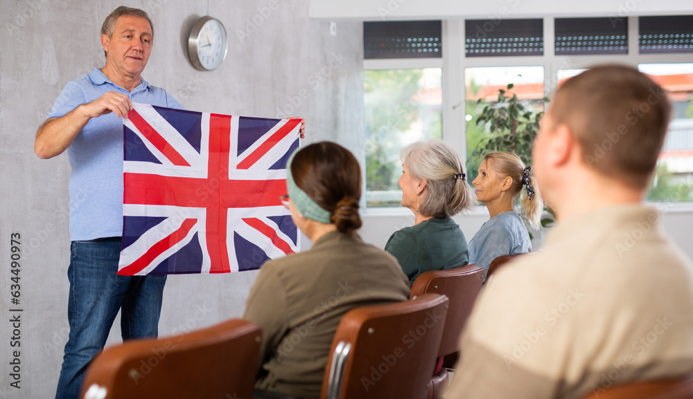 Portrait of elderly male tutor giving lecture to group of older adults ...