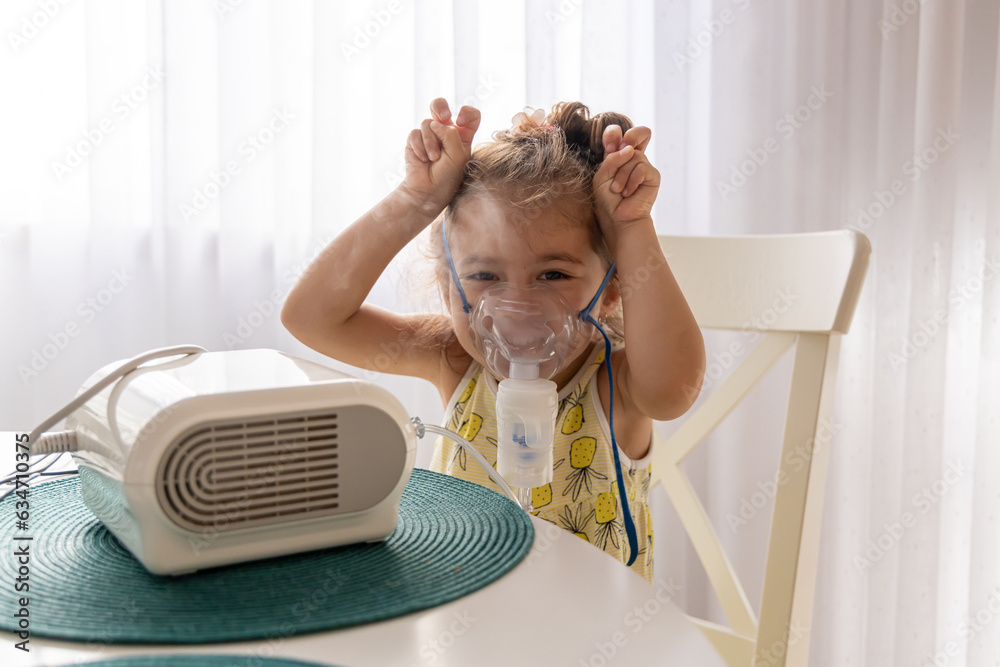 Cute little girl in the mask of an inhaler. Having fun. Procedure of ...