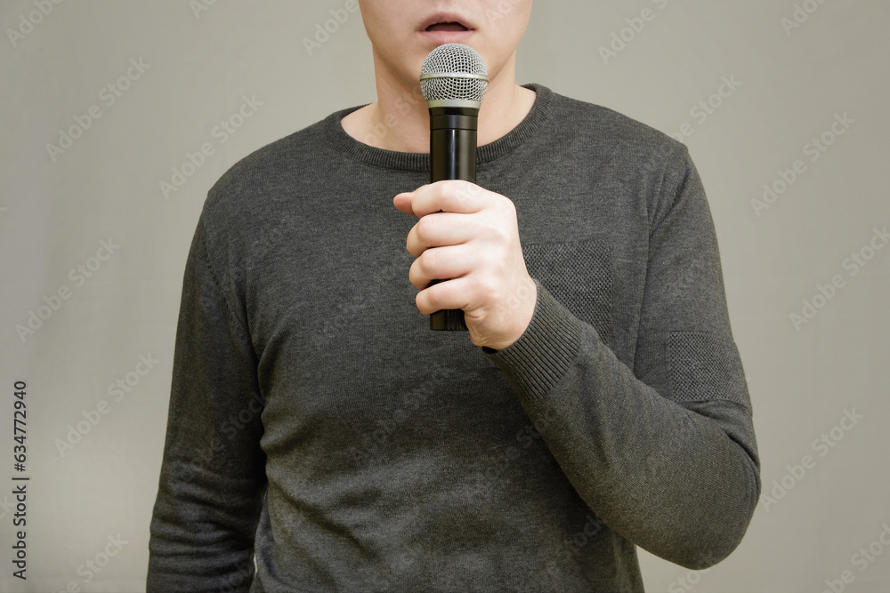 Young man speaking into microphone. Freedom of speech, singing karaoke ...