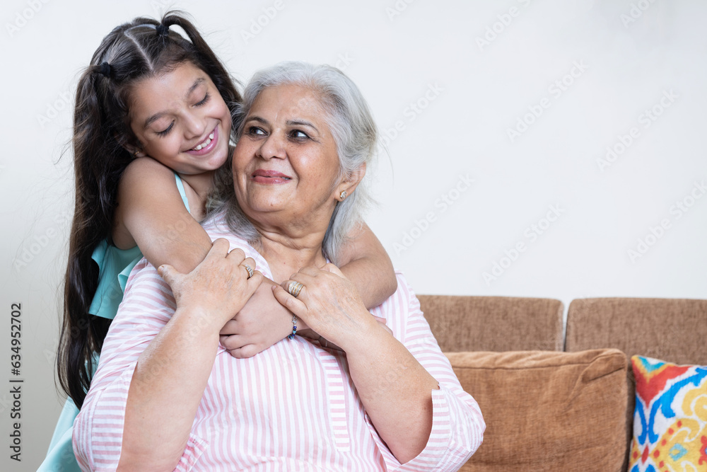 Cute caring small Indian granddaughter embrace cuddle smiling middle ...